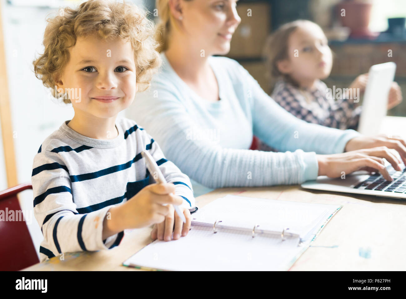 Cute Curly Haired Kid Writing Stock Photo - Alamy