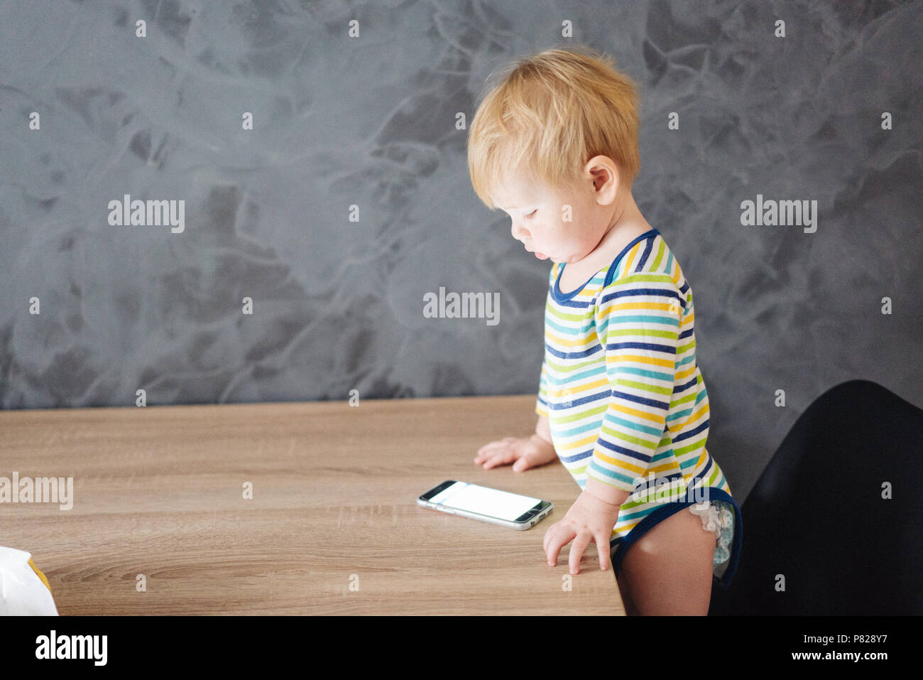 baby boy standing near the table Stock Photo - Alamy