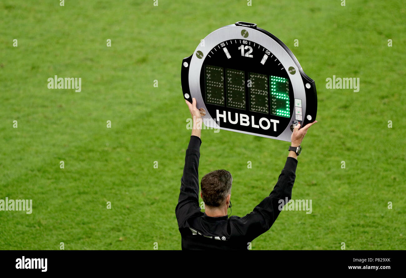 The fourth official holds up an electronic board signalling five ...