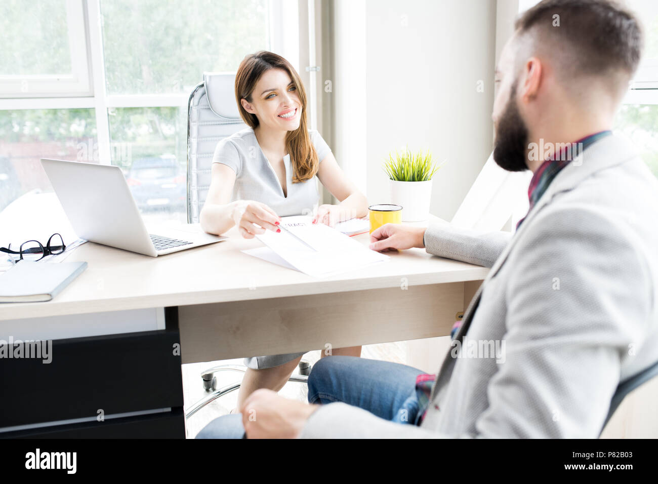 Smiling Businesswoman Talking to Client Stock Photo - Alamy