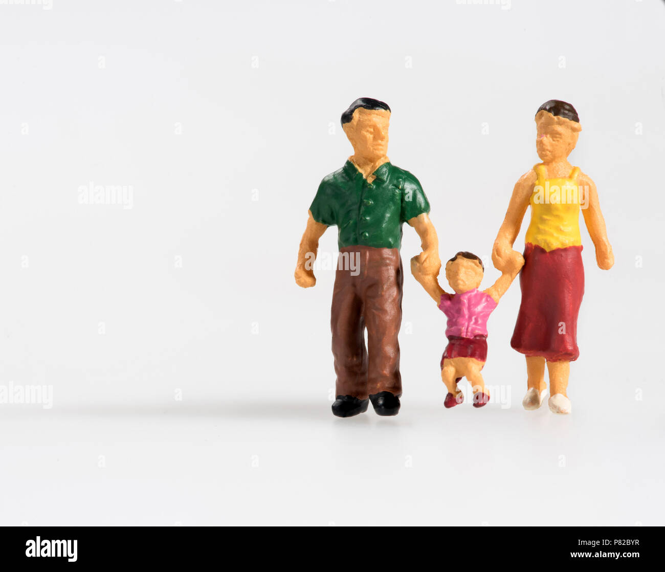 Happy family with small child miniature toy people with the parents ...