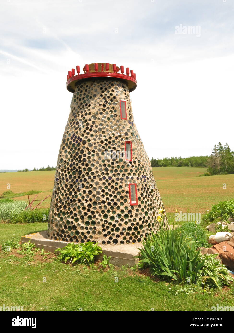 A model of a lighthouse made of glass bottles in cemented walls; Hannah ...