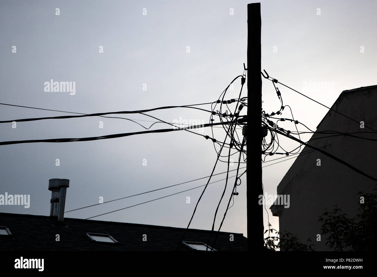 Interlacing electric wires in a big city against the sky. Silhouette of ...