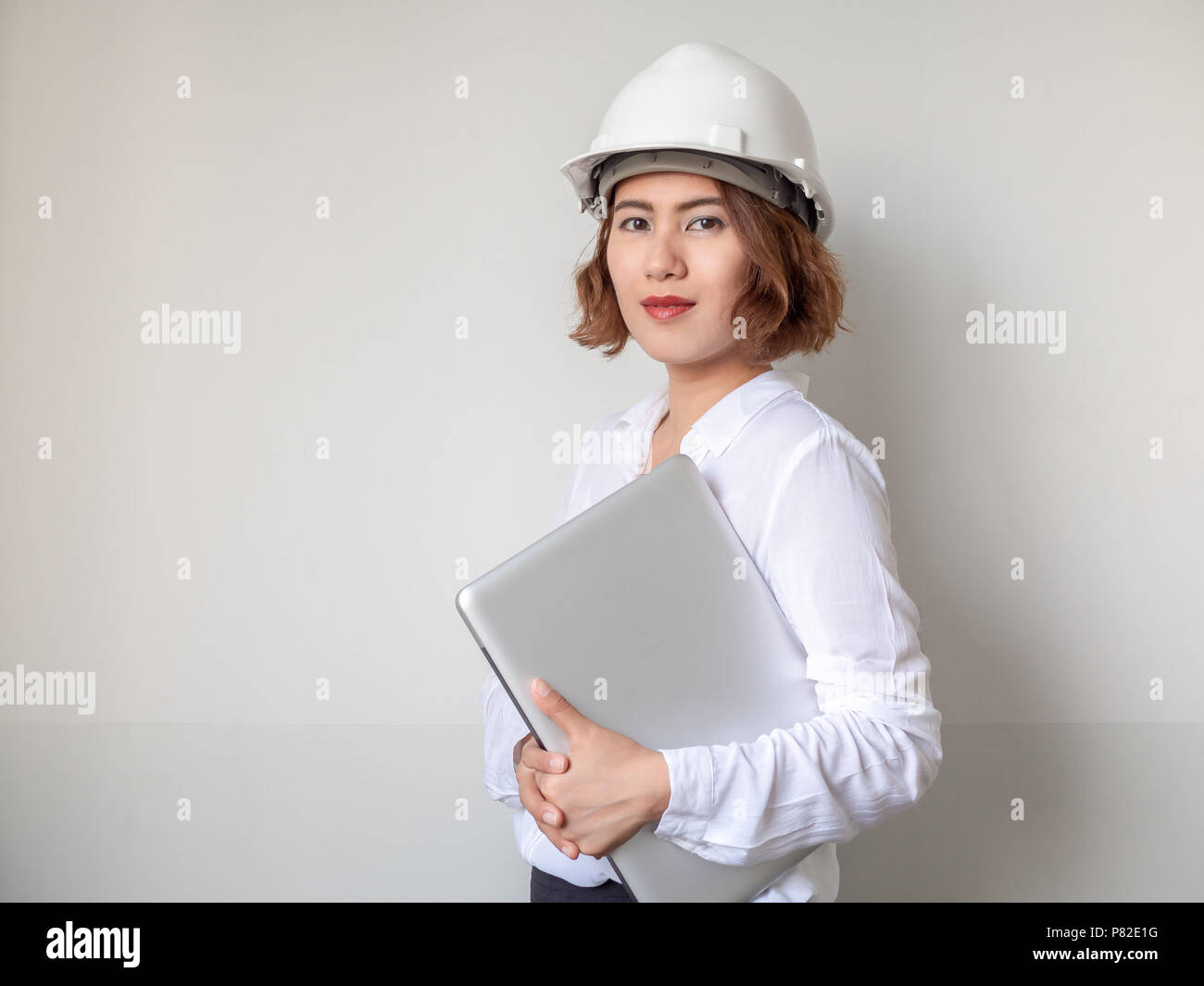 Beautiful asian woman engineer curly short hair wearing white safety ...