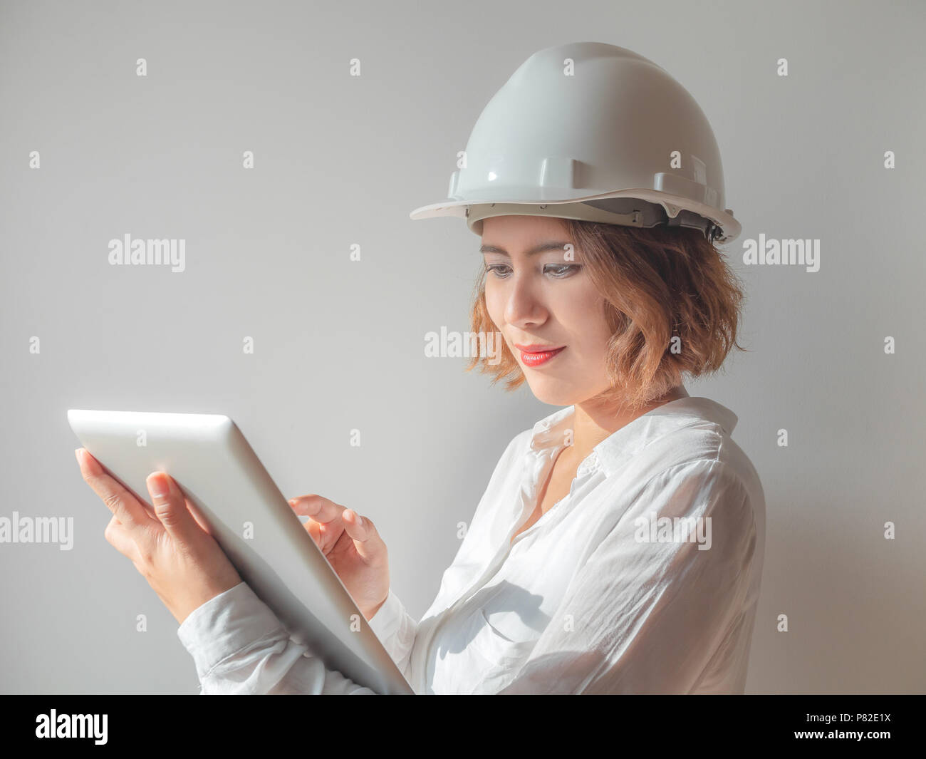 Beautiful asian woman engineer curly short hair wearing white safety ...