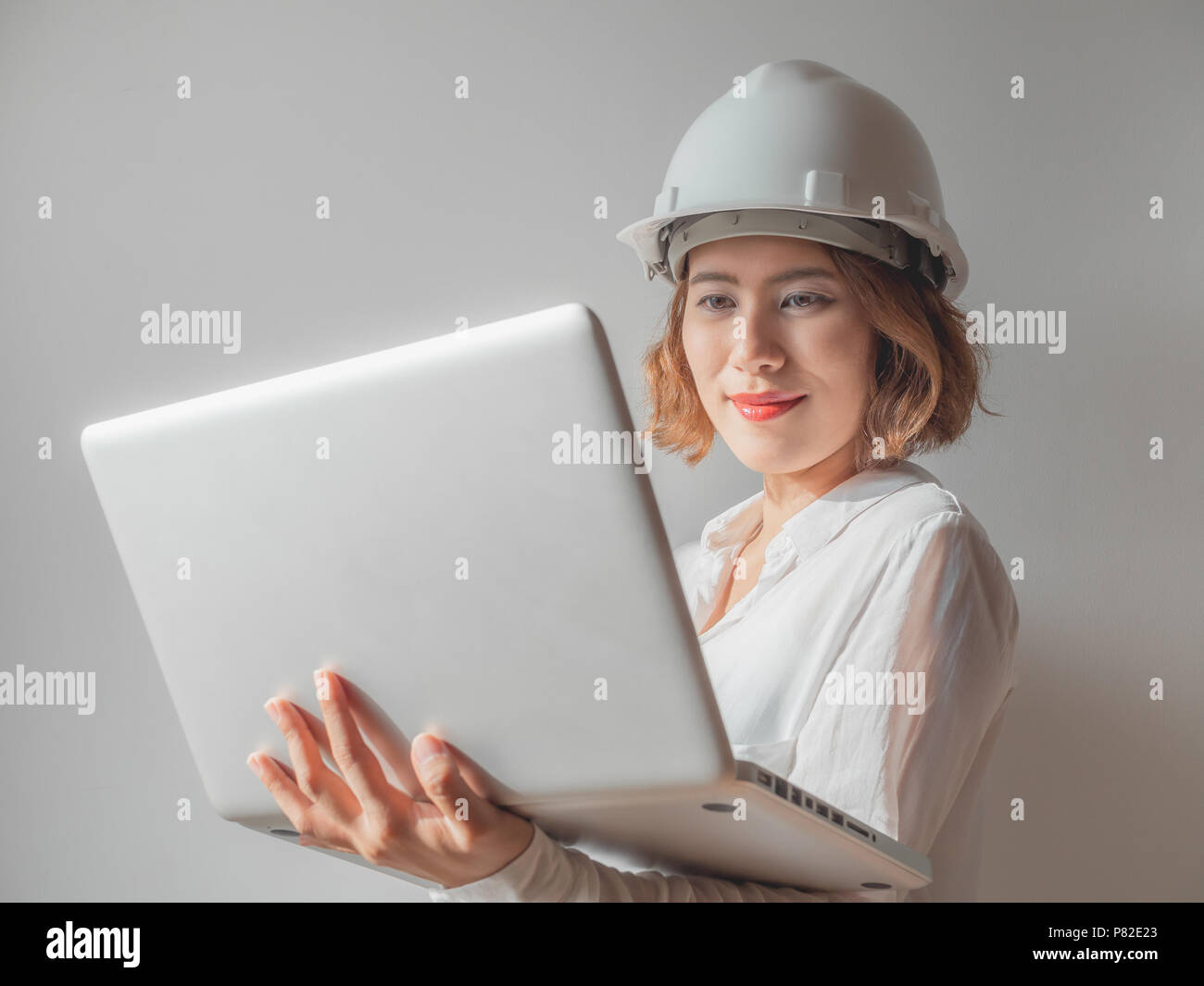 Beautiful asian woman engineer curly short hair wearing white safety ...