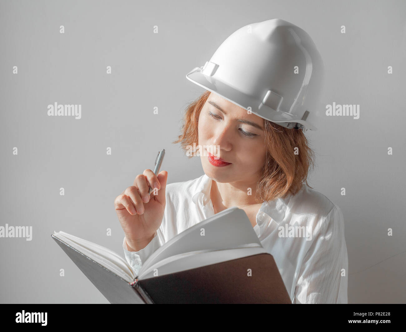Beautiful asian woman engineer curly short hair wearing white safety ...