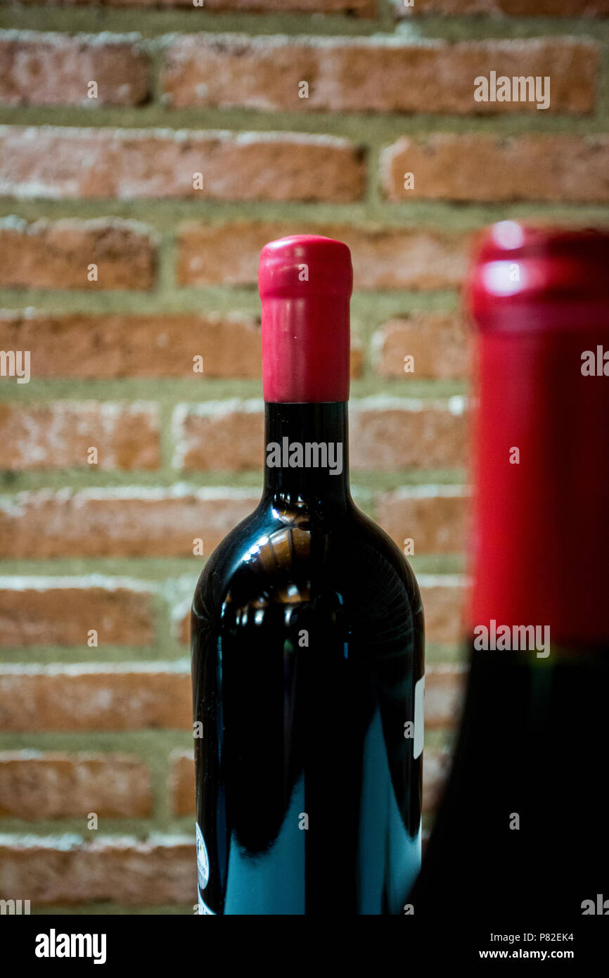 Bottles of red wine on a brick wall background Stock Photo - Alamy