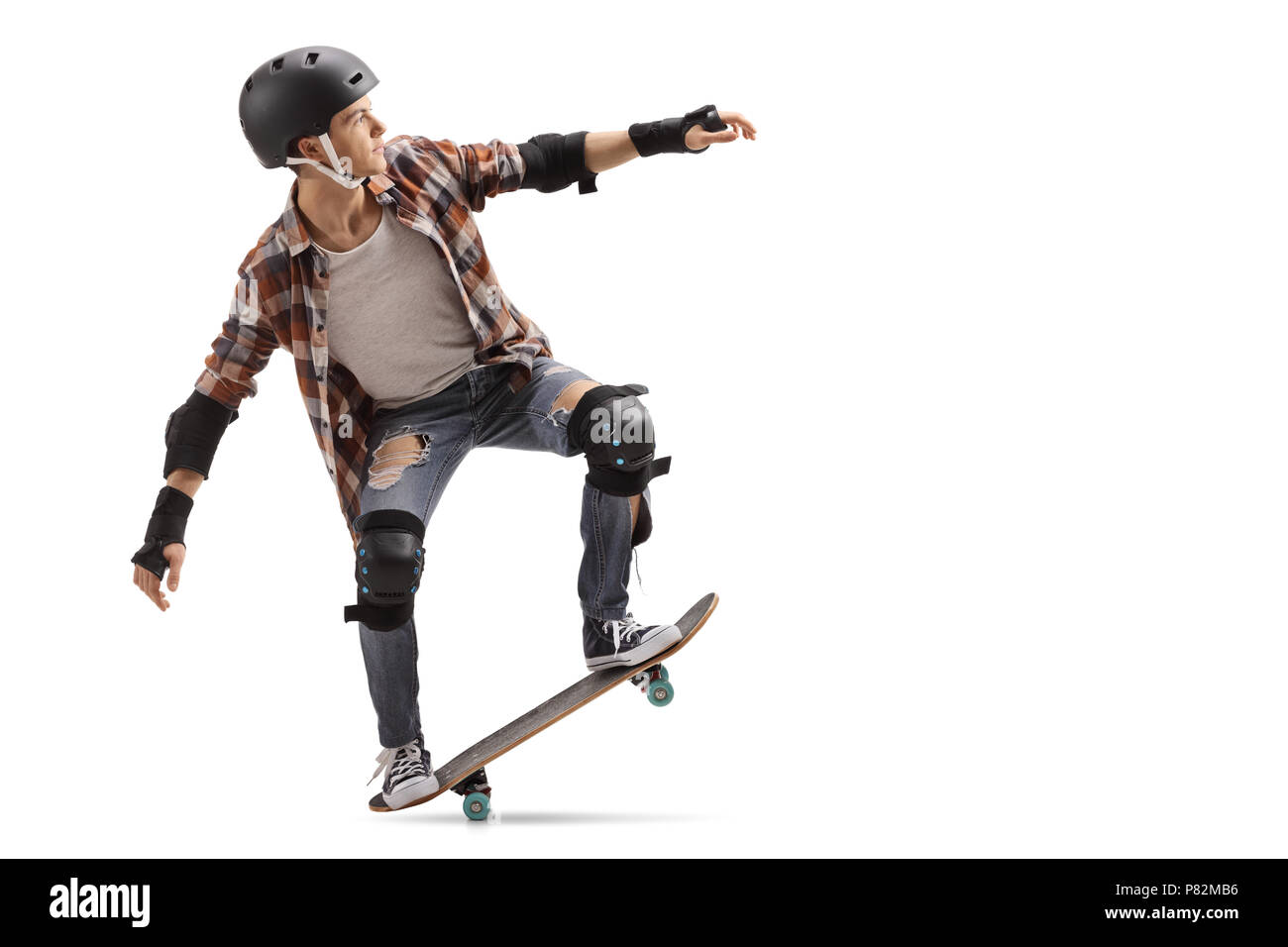 Full length profile shot of a teenage skater performing a manual ...