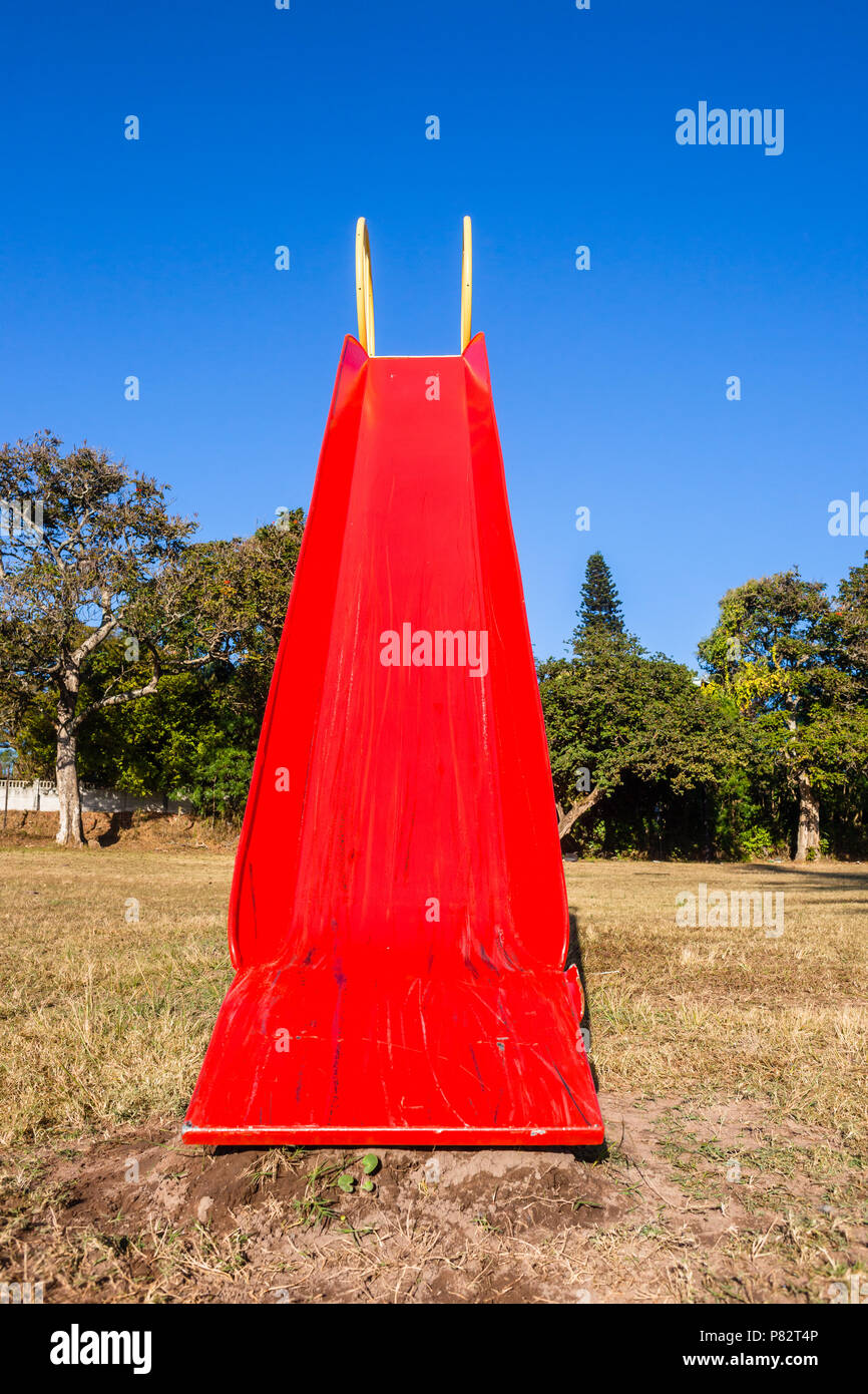 Playground closeup inside children's red painted slide chute looking ...