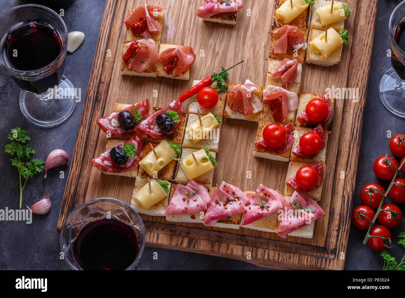 Close view of tiny spanish tapas with jamon, sausage, cheese and wine ...