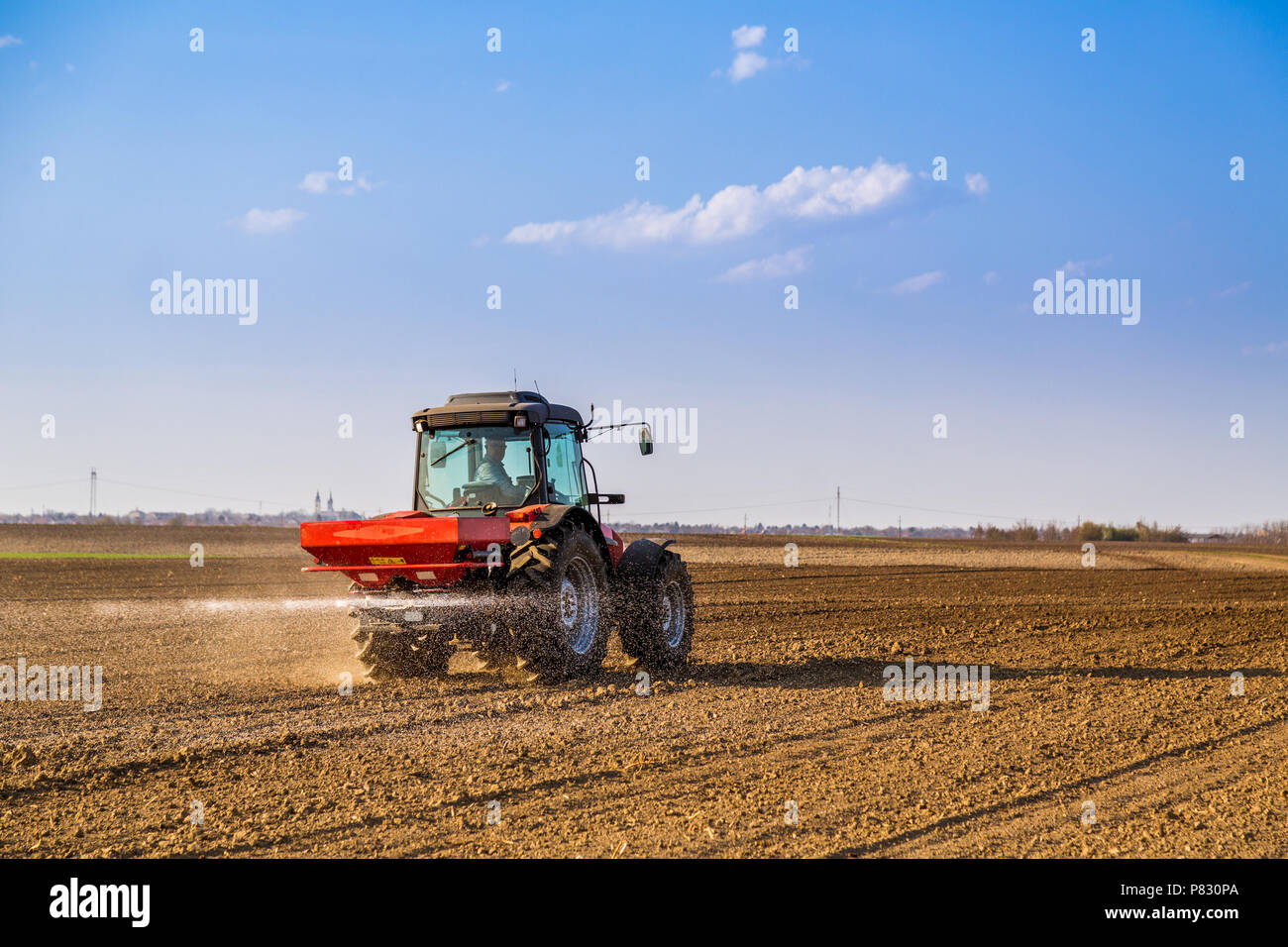 Farmer fertilizing arable land with nitrogen, phosphorus, potassium ...