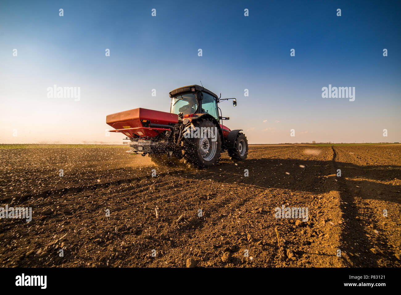 Farmer fertilizing arable land with nitrogen, phosphorus, potassium ...
