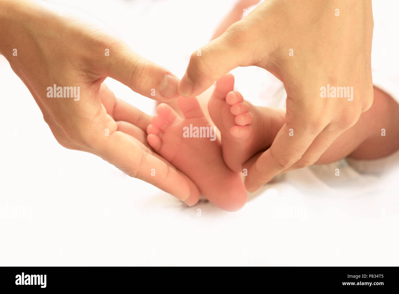 heart shape with the new born legs Stock Photo - Alamy