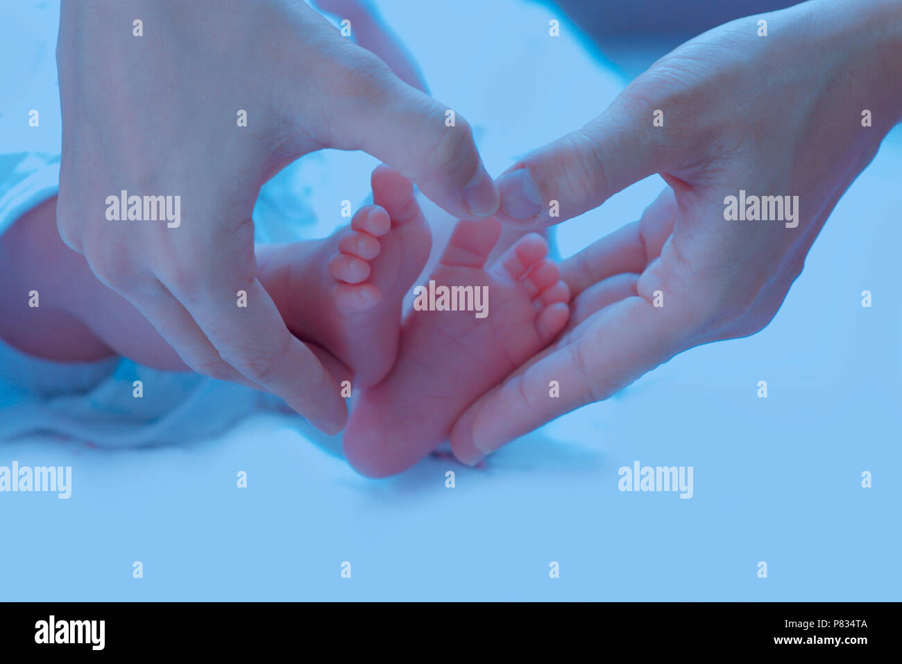 heart shape with the new born legs Stock Photo - Alamy