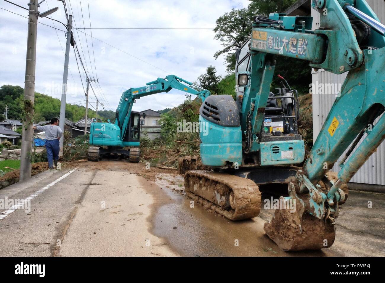 June 8, 2018. Earth movers work to clean up landslides in Hojo, Ehime ...