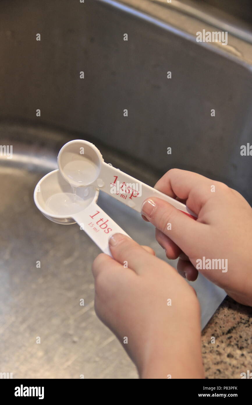 Pouring water from teaspoon to tablespoon Stock Photo - Alamy