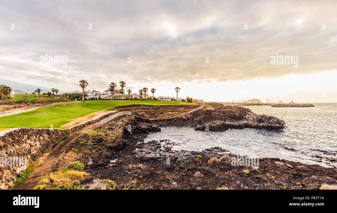Ground path with handrails and golf course along rocky coastline ...