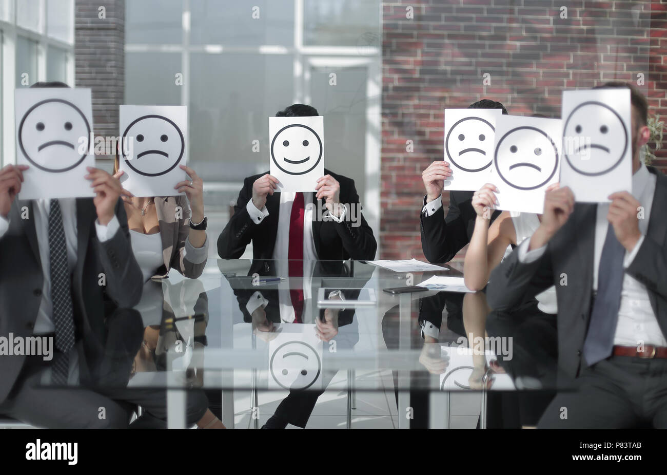 business partners with smiley icons sitting at the Desk Stock Photo - Alamy