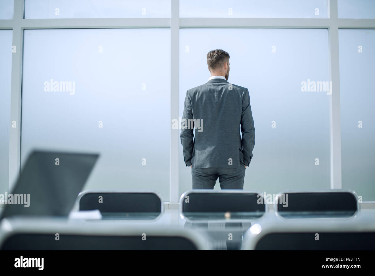 rear view.businessman looking in the office window Stock Photo - Alamy