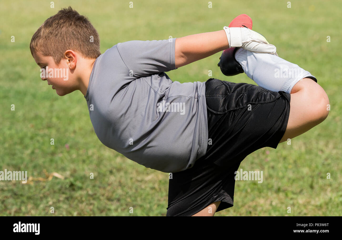 Kids soccer football - little goalkeeper is stretching, exercising ...