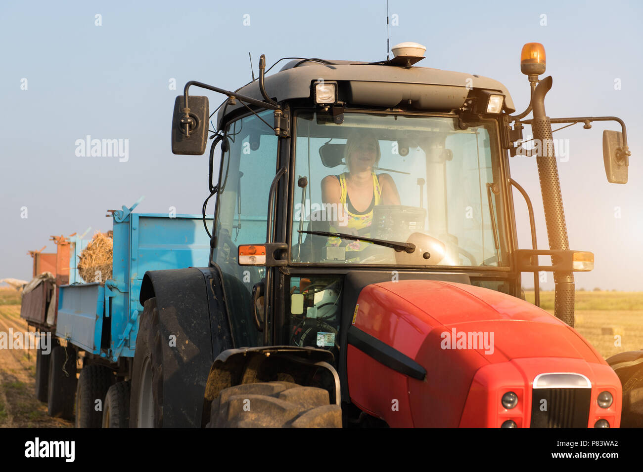 Beautiful, young farmer girl is driving tractor at field Stock Photo ...