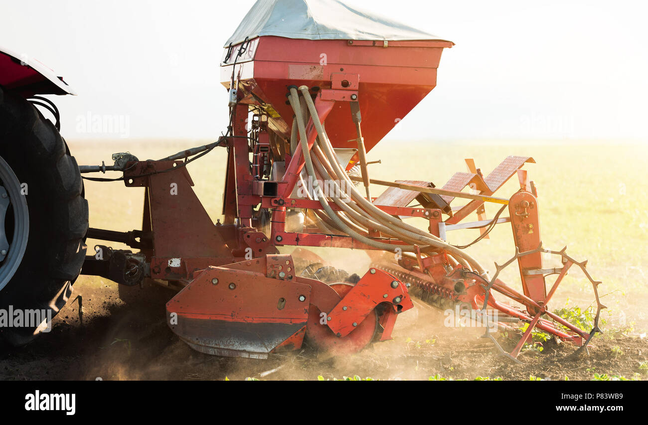Farmer with tractor seeding - sowing crops at agricultural fields in ...