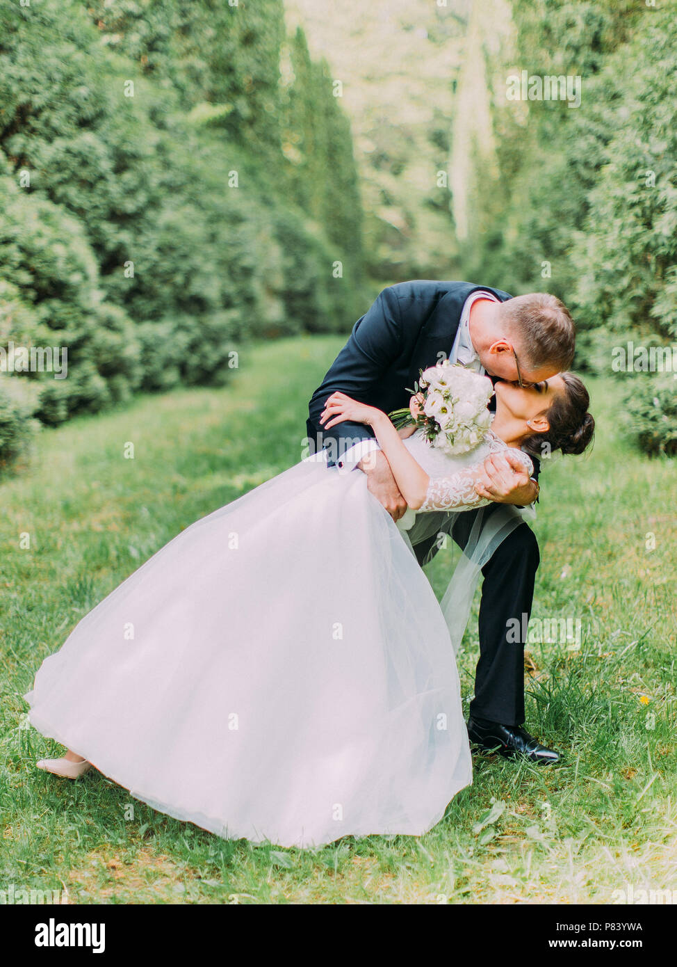 Kissing newlyweds during the dance in the spring garden Stock Photo - Alamy