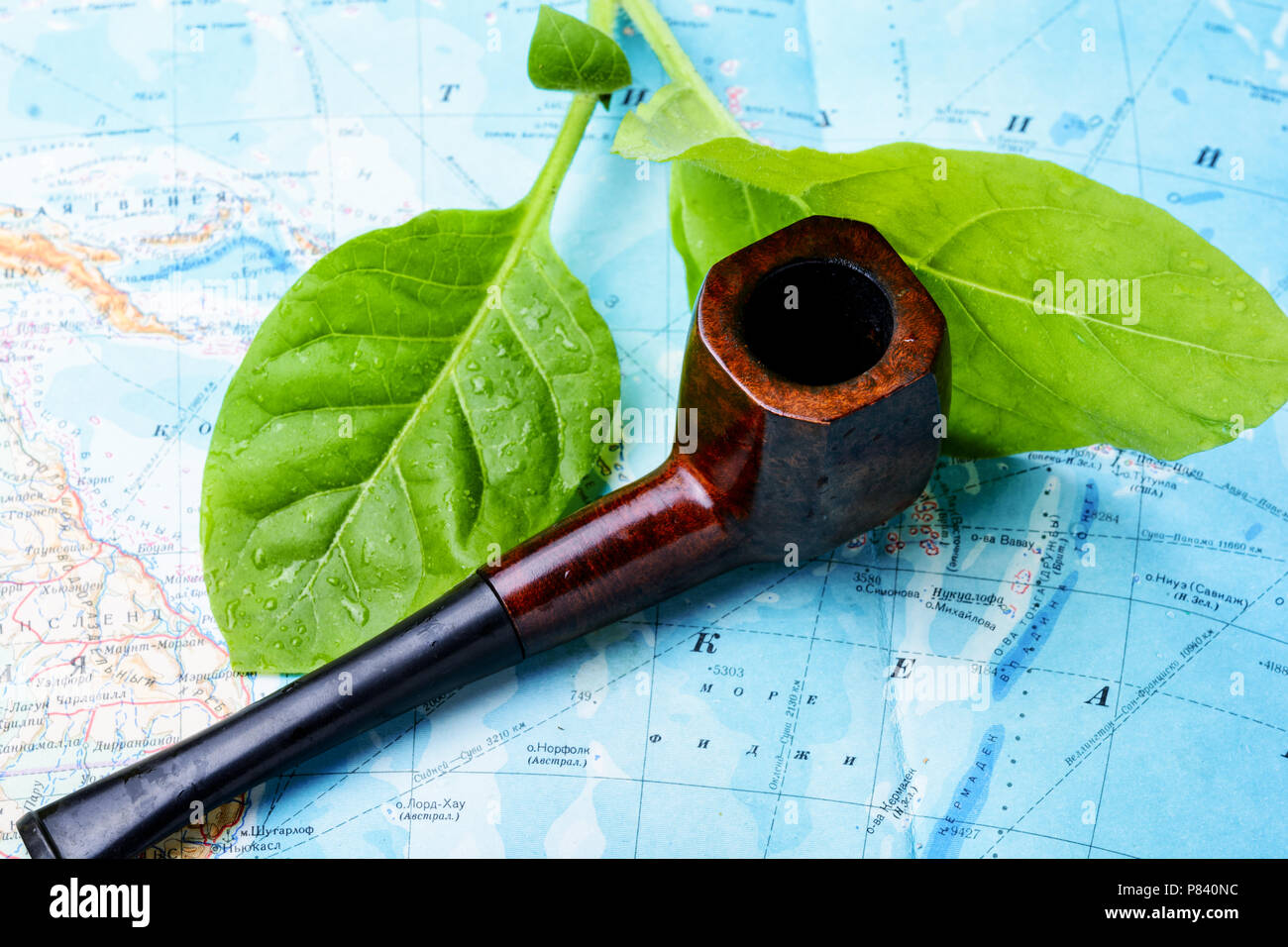 Smoking pipe, tobacco leaves on the world map Stock Photo - Alamy