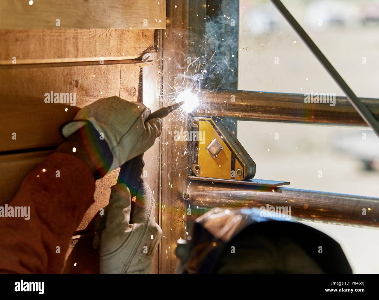 A welder welding a steel pipe to the steel frame of a barn Stock Photo ...