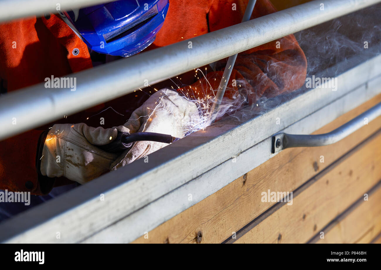 A welder welding a steel bar to the steel frame of a barn Stock Photo ...