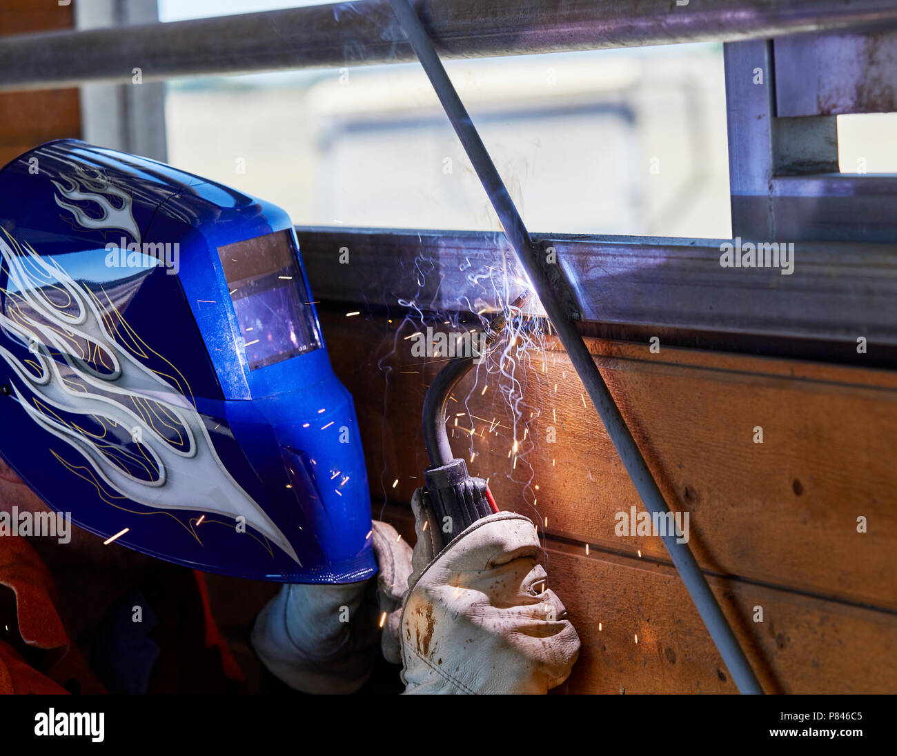 A welder welding a steel bar to the steel frame of a barn Stock Photo ...