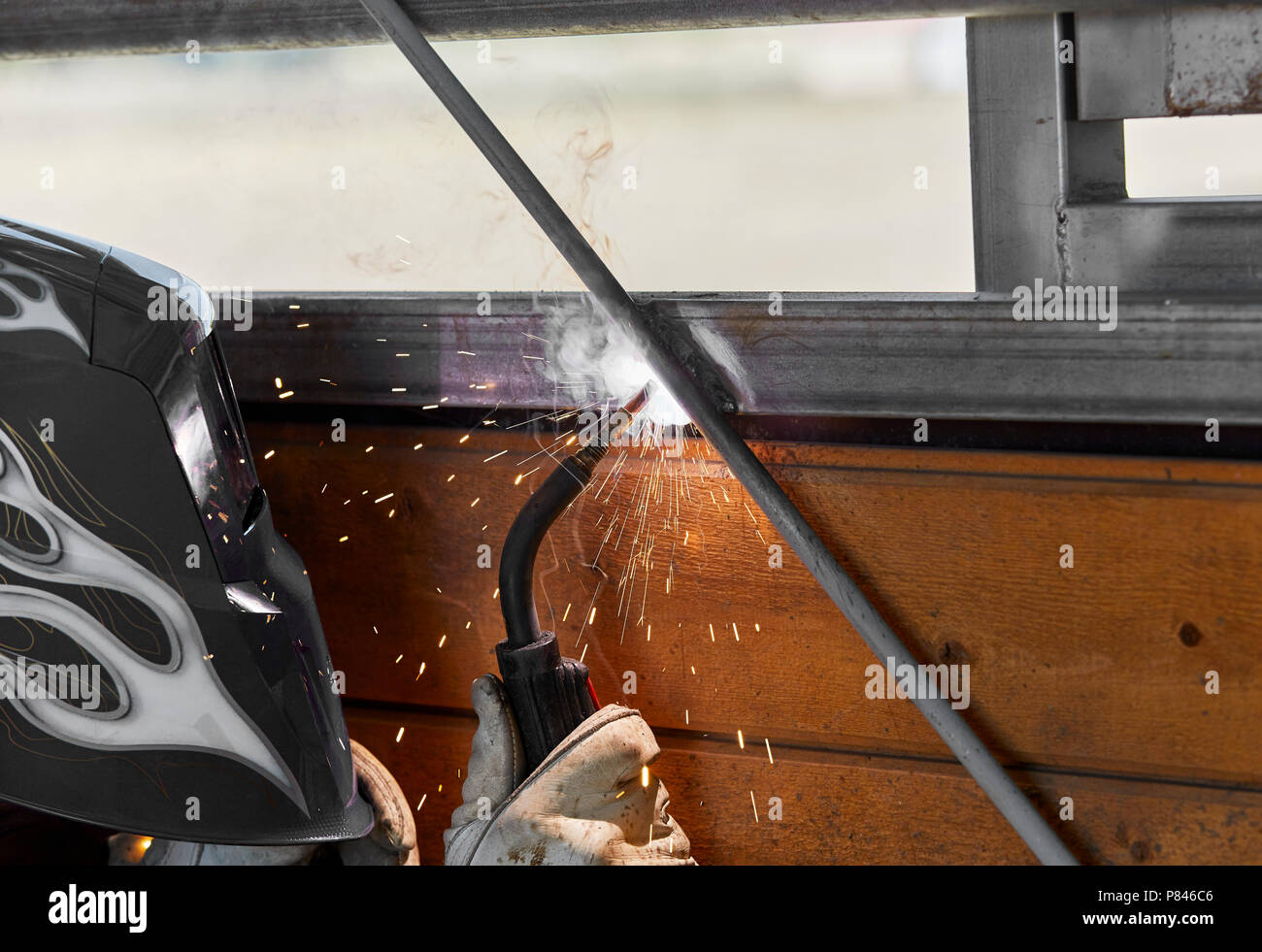 A welder welding a steel bar to the steel frame of a barn Stock Photo ...