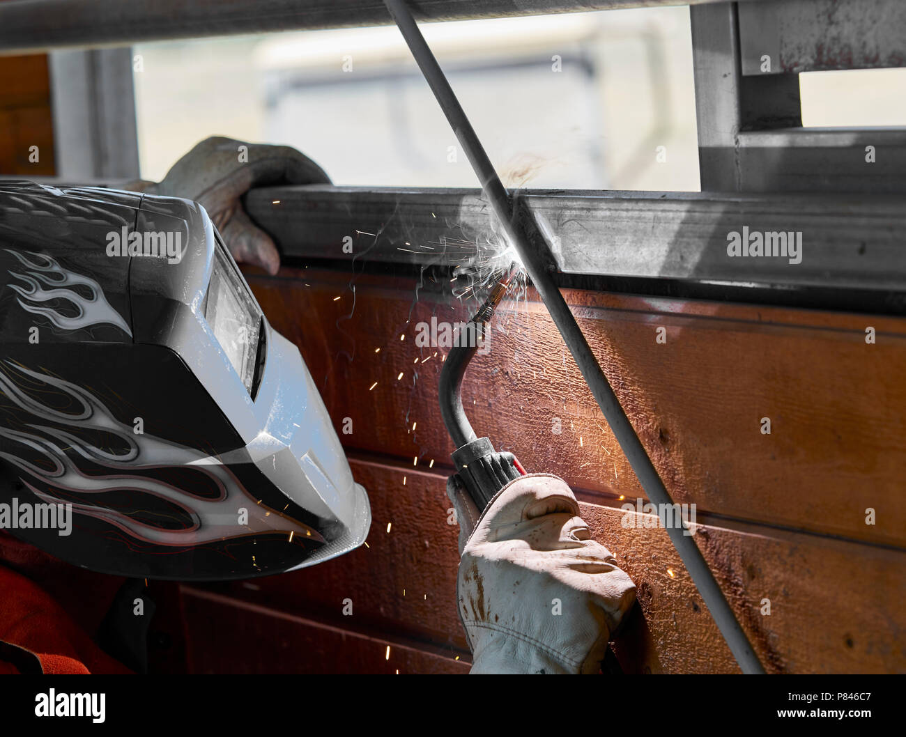 A welder welding a steel bar to the steel frame of a barn Stock Photo ...
