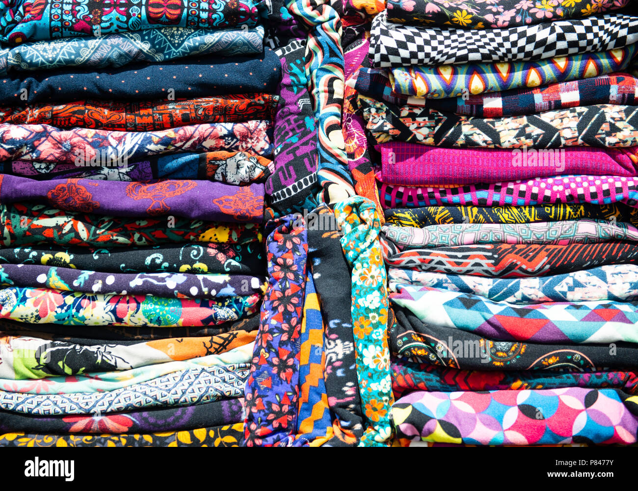 Brightly colored and patterned cloth, folded and stacked into an ...