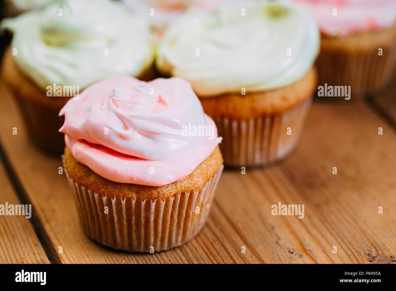 Dessert Sweet Gourmet Cupcakes With Multi-colored Frosting On Wooden ...