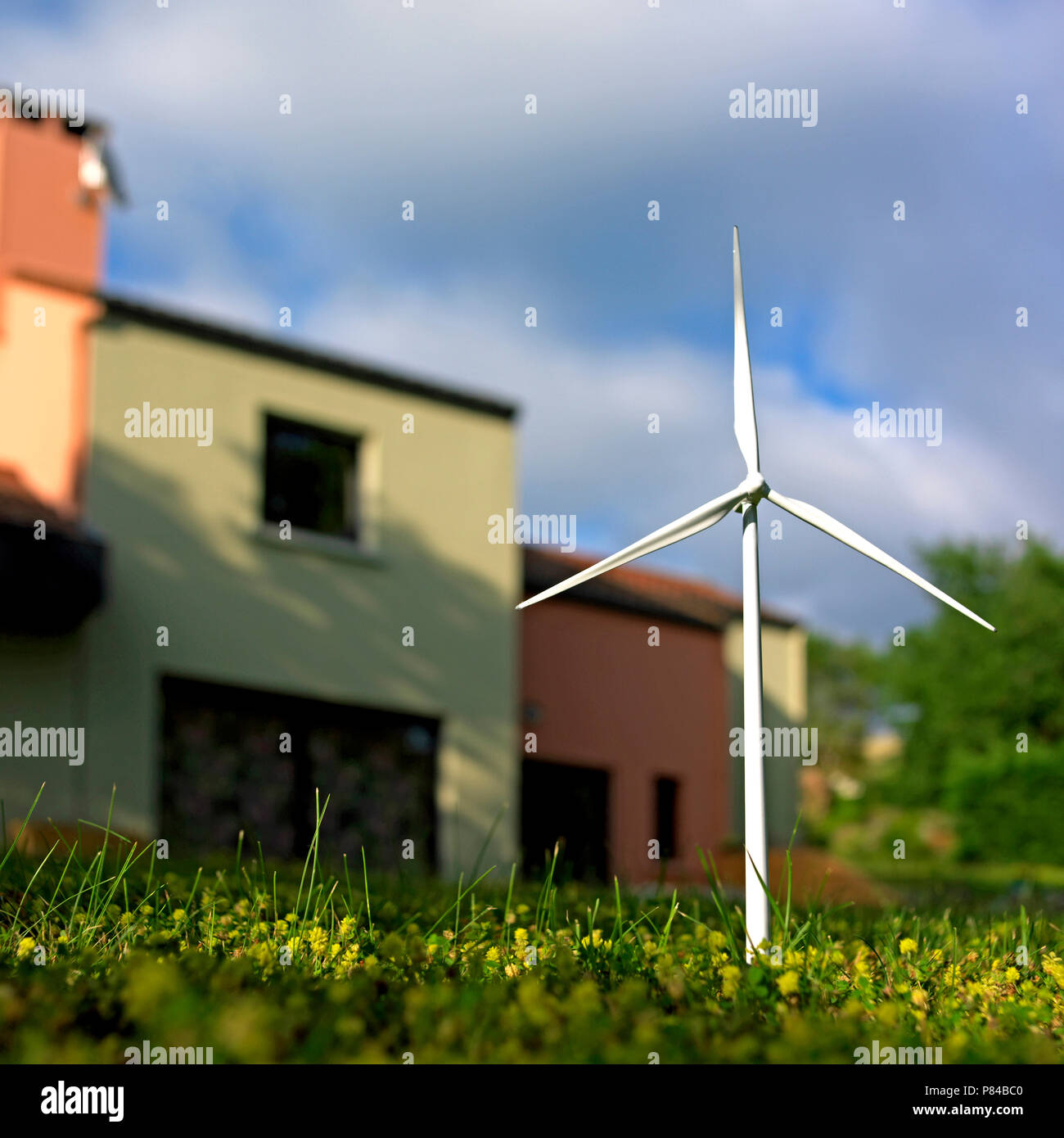 Miniature wind turbine in the grass in front of a sunny house Stock ...