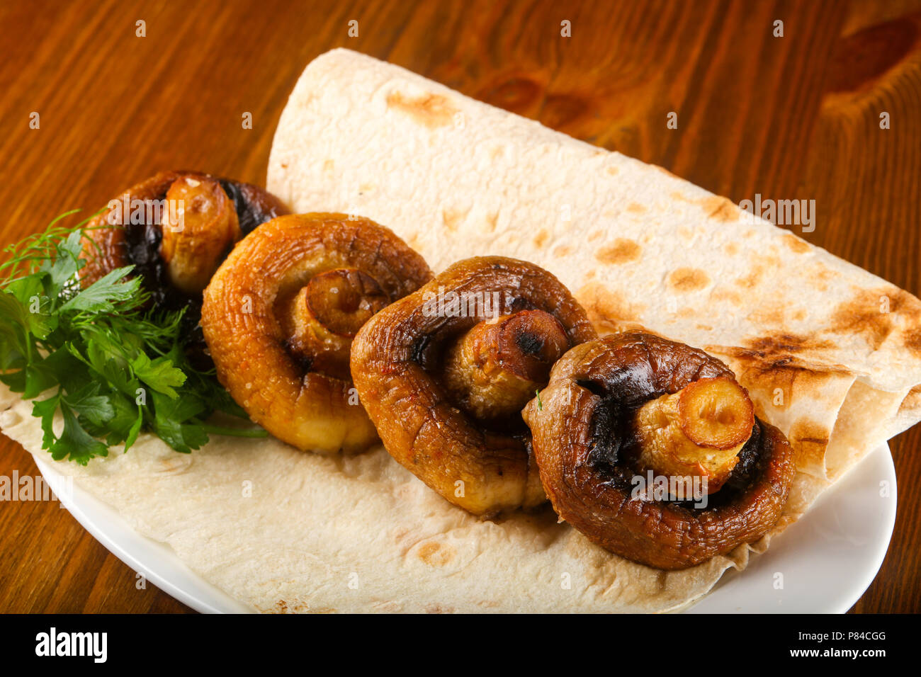 Grilled champignons with bread lavash Stock Photo - Alamy