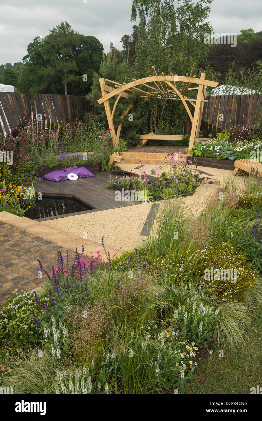 Colourful flowers, timber pergola, bench & pond in beautiful prize ...