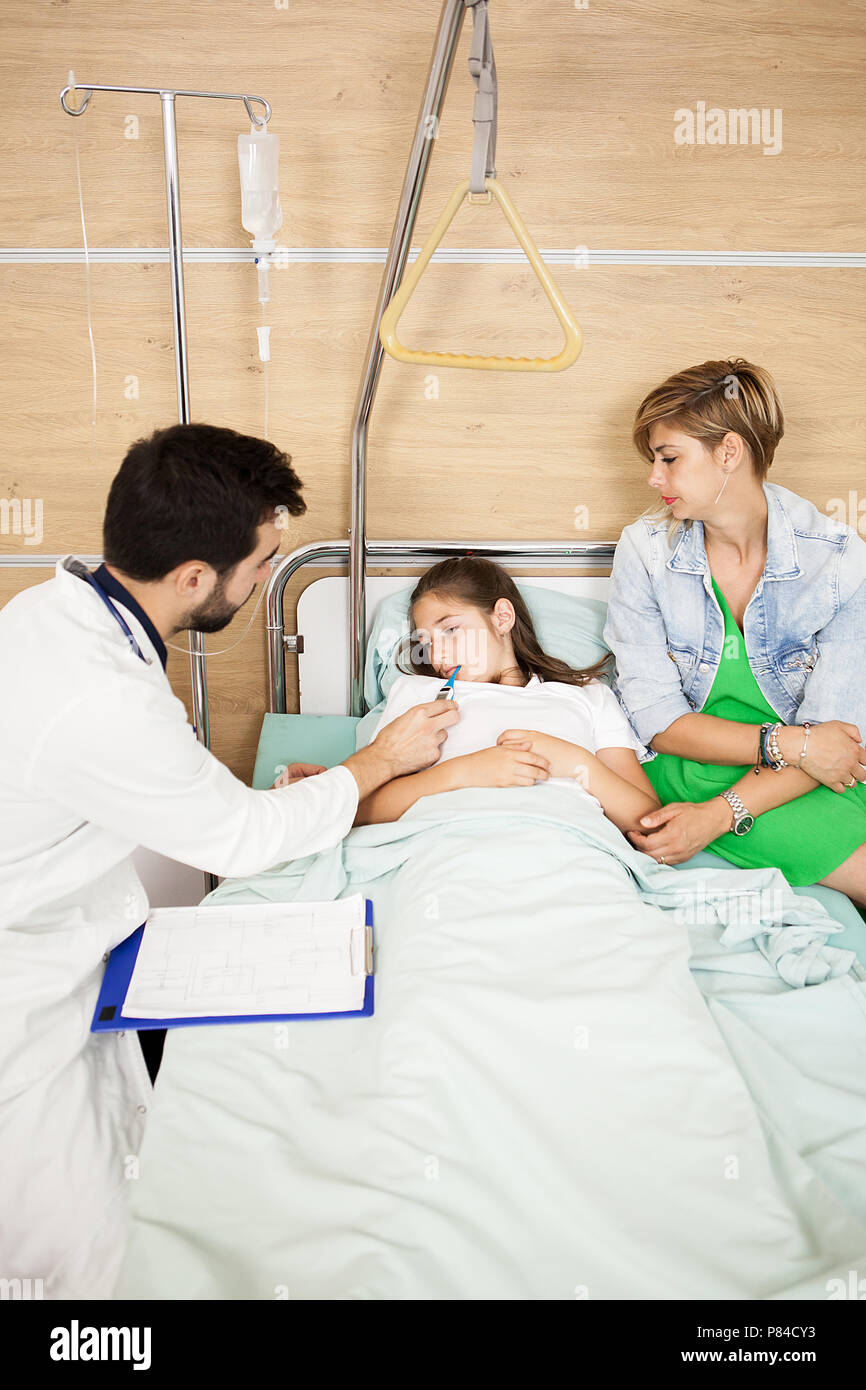 Doctor taking body temperature of her patient in hospital room Stock ...
