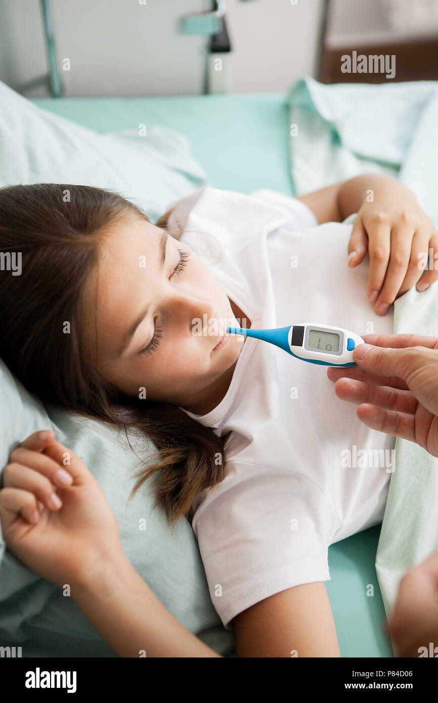 Doctor taking body temperature of her patient in hospital room Stock ...