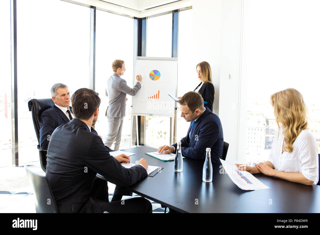 Group of business people at meeting watching presentation of reports in ...