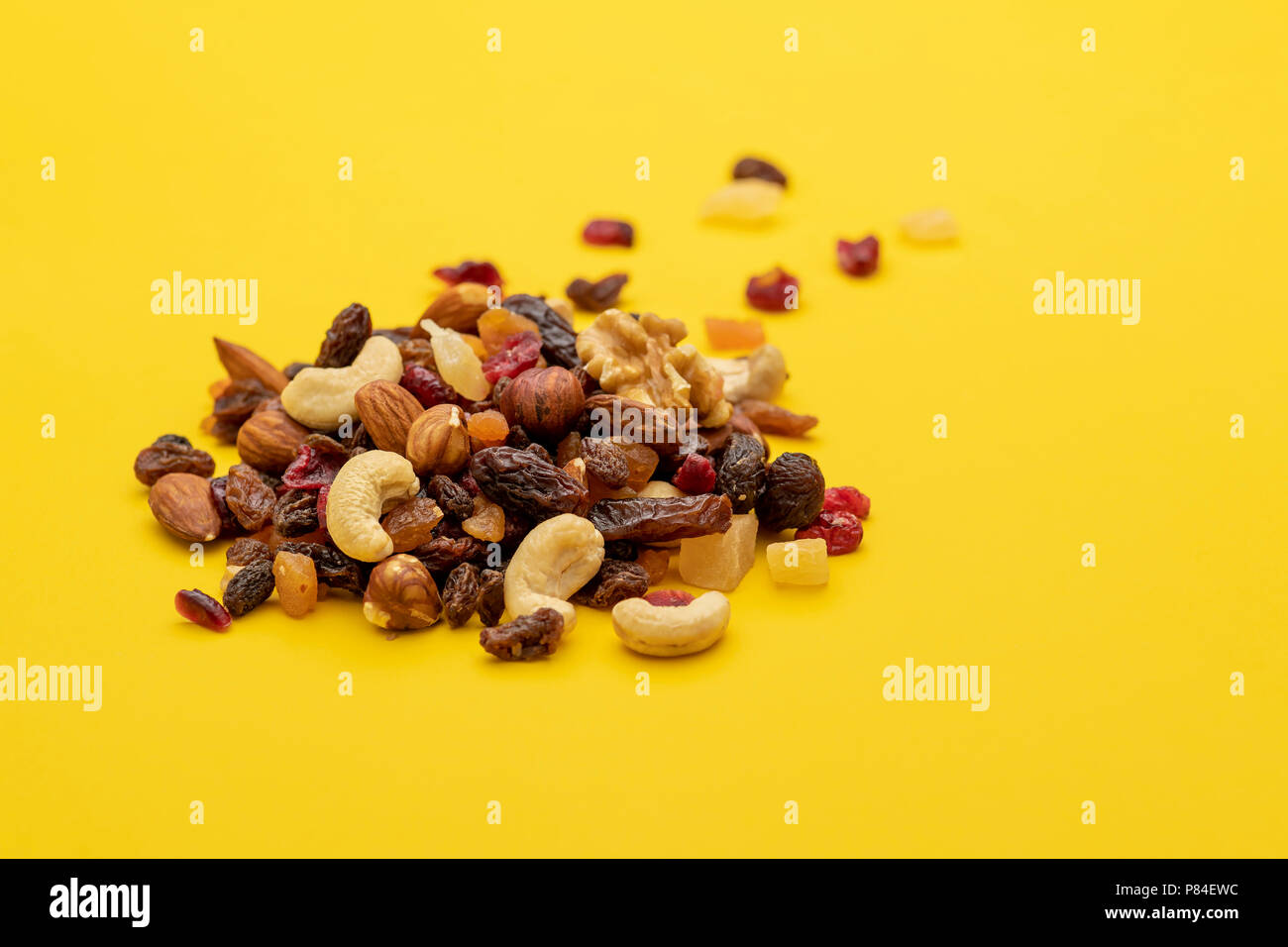 Mix of dried fruits and nuts on a yellow background Stock Photo - Alamy
