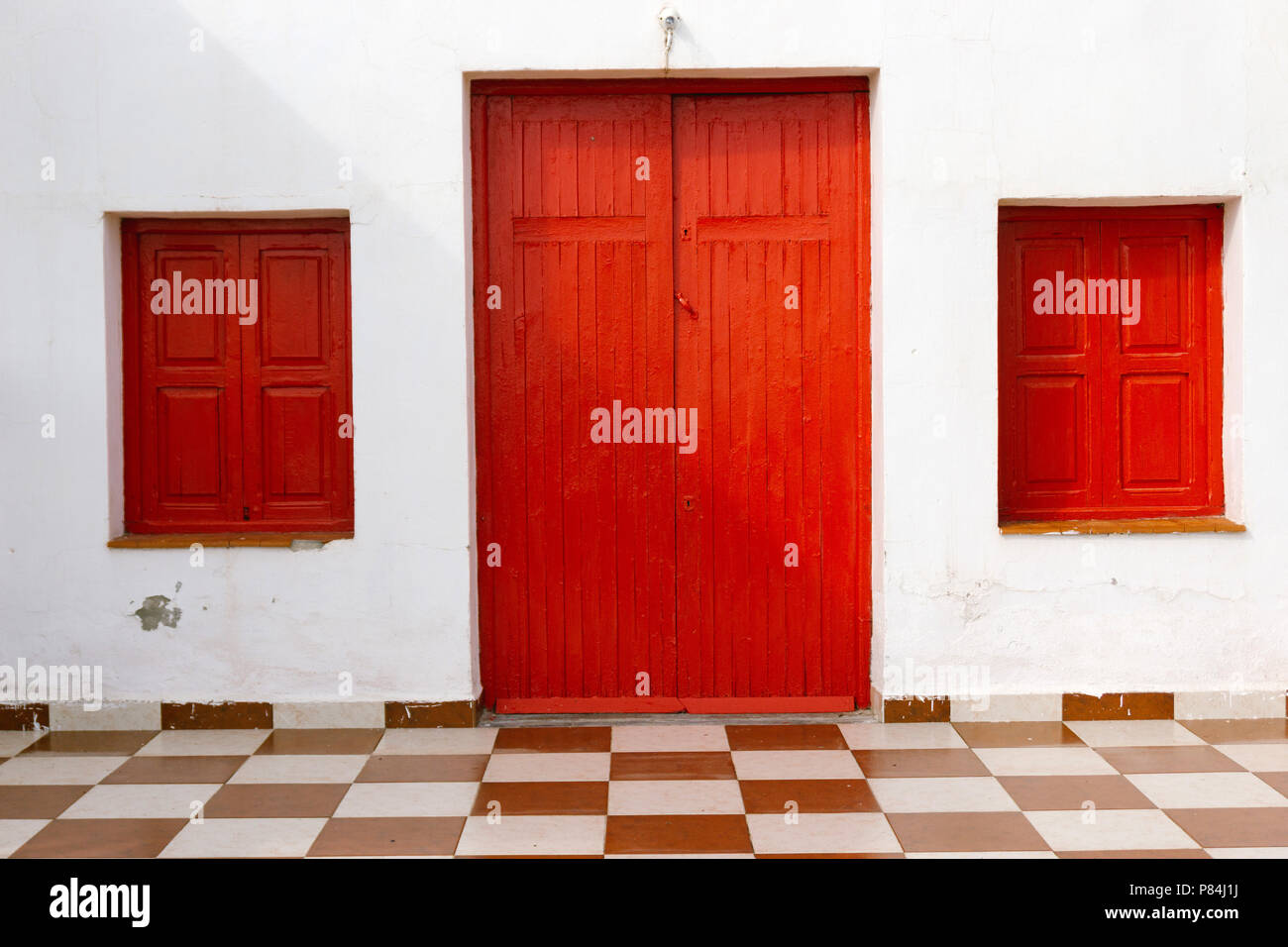 House with white walls and red door and windows Stock Photo - Alamy