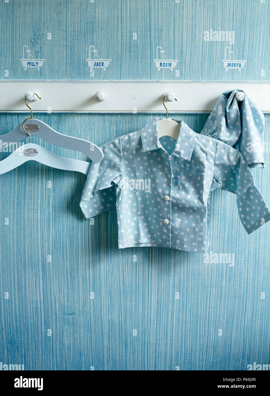 Close-up of a pegboard with a pair of children's pyjamas on a wall with ...