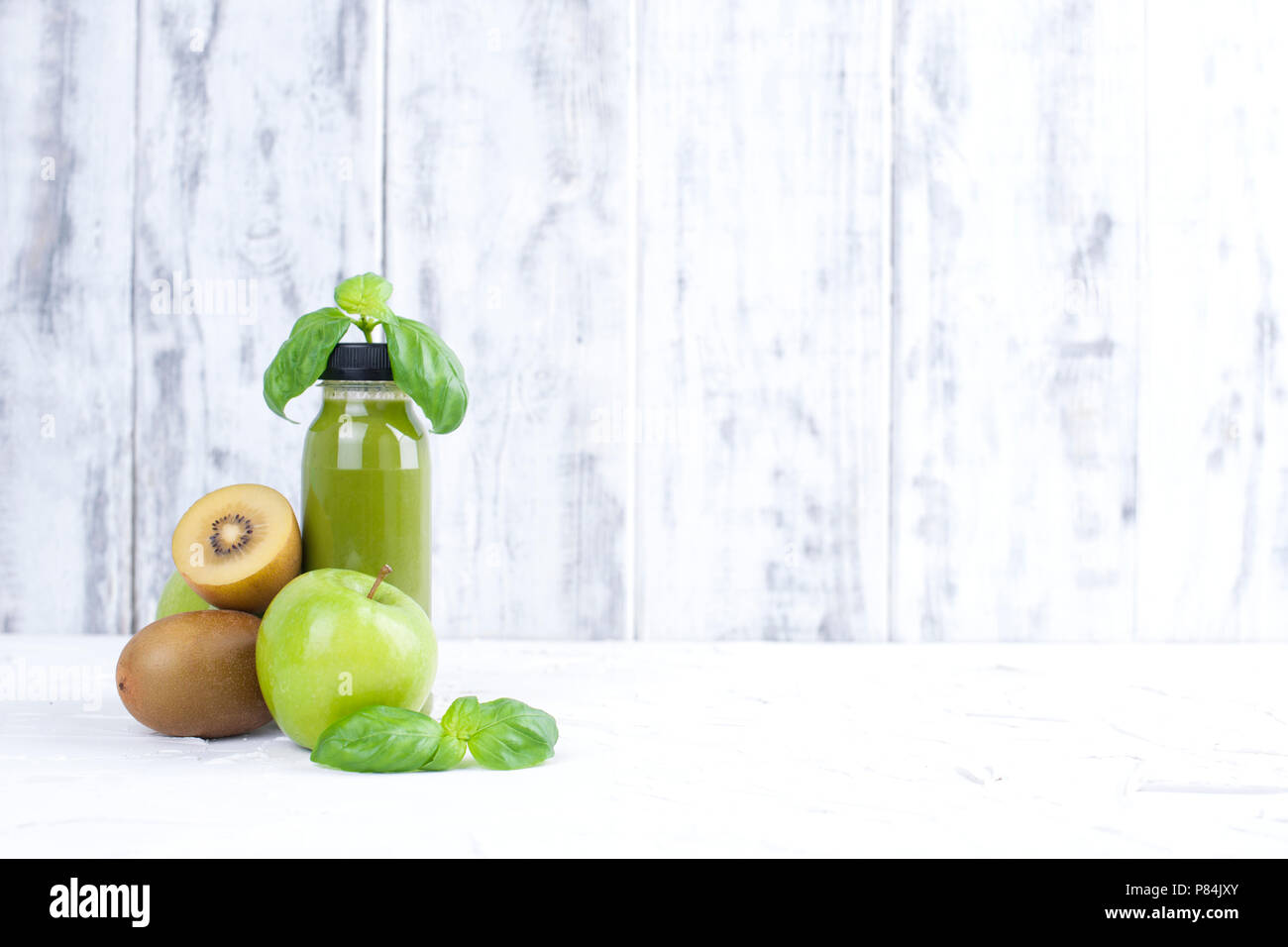 Kiwi, green apple, basil and. juice in a plastic bottle. Detox food ...
