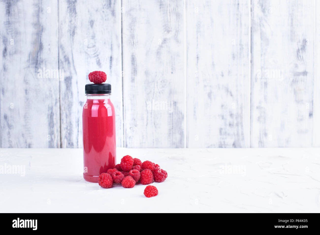 Fresh raspberry and juice in a plastic bottle. Detox. White background ...