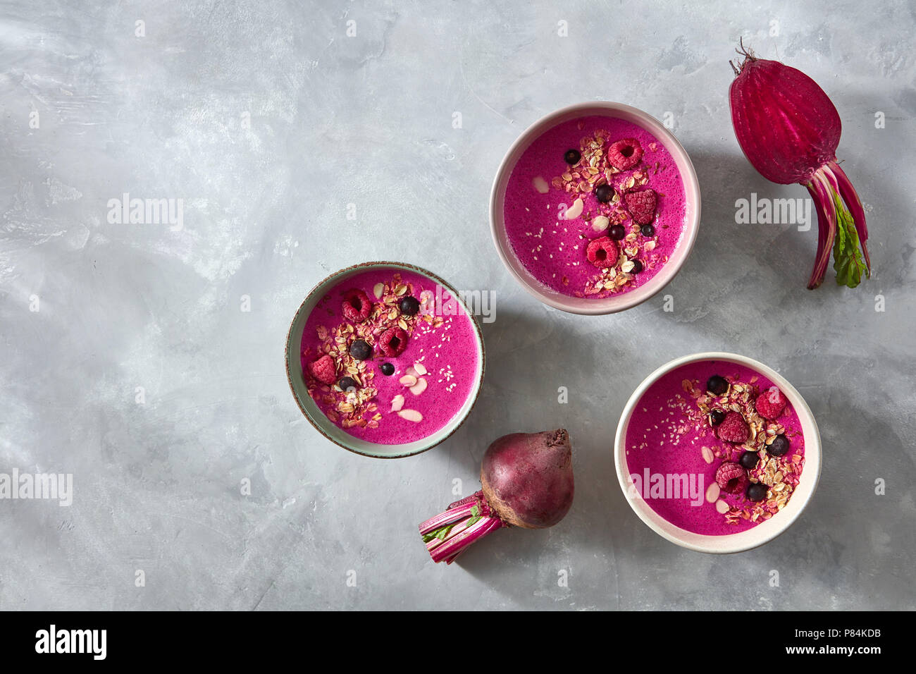 Red smoothies with berries and oatmeal on a concrete background with ...