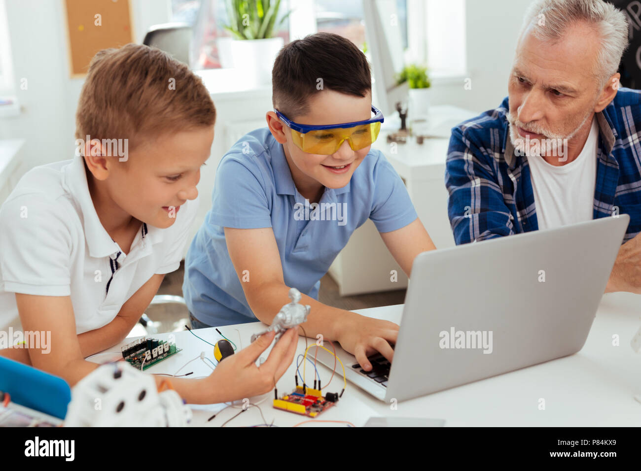 Positive nice boy sitting in front of the laptop Stock Photo - Alamy