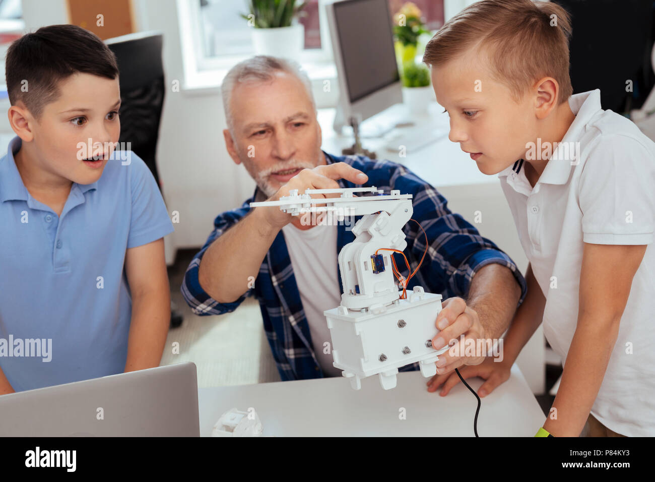 Smart curious boys looking at the modern robot Stock Photo - Alamy